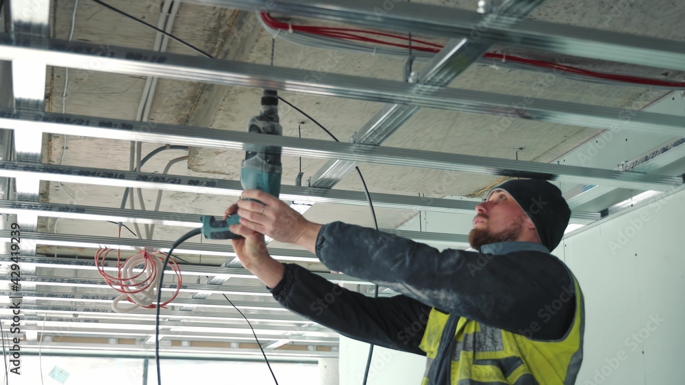 A master who drills a hole in the ceiling with a drill. Creation of ...