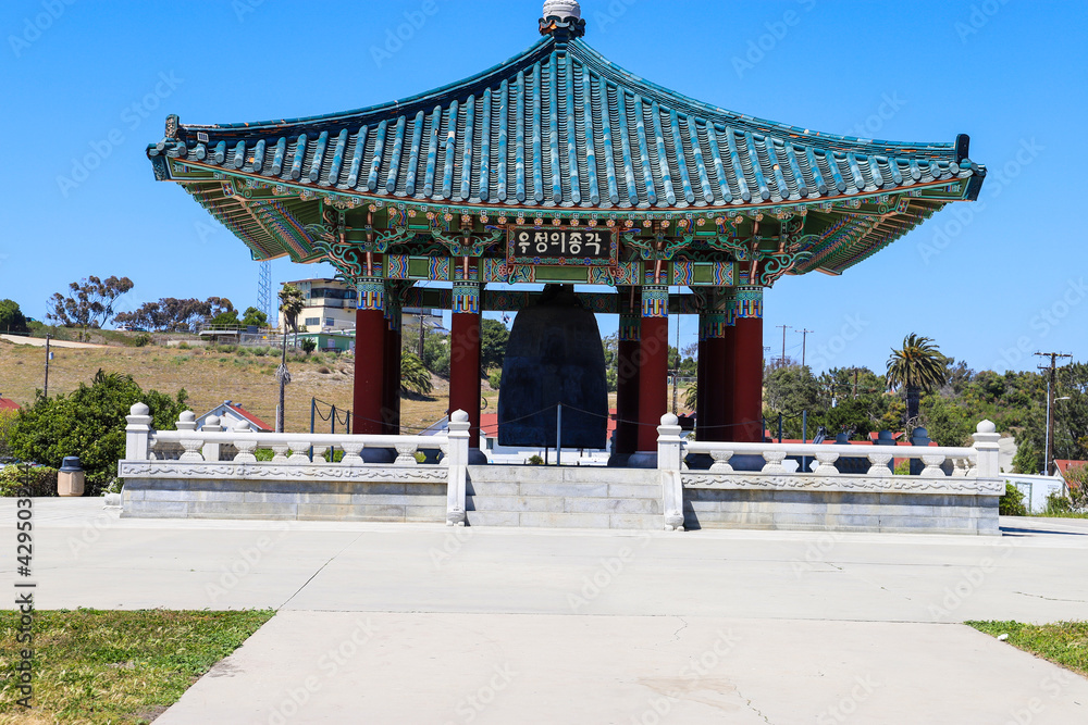 a red and green Korean Pavilion with massive bronze bell in the center ...
