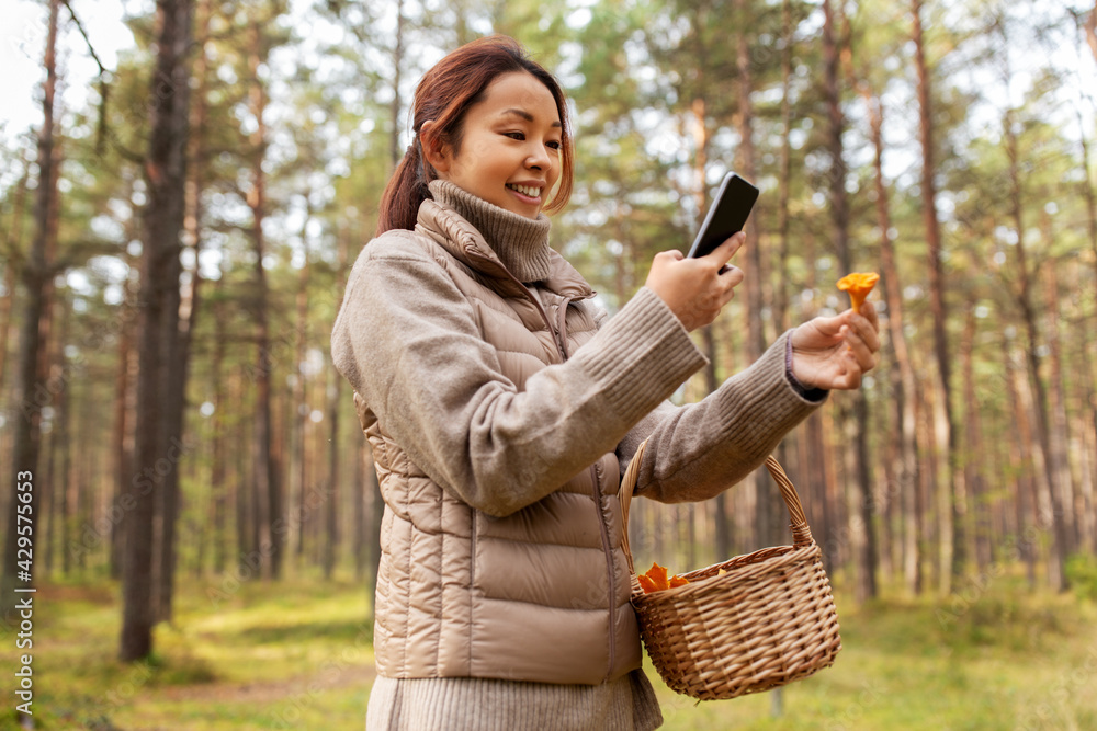 technology, leisure and people concept - young asian woman with smartphone using app to identify ...