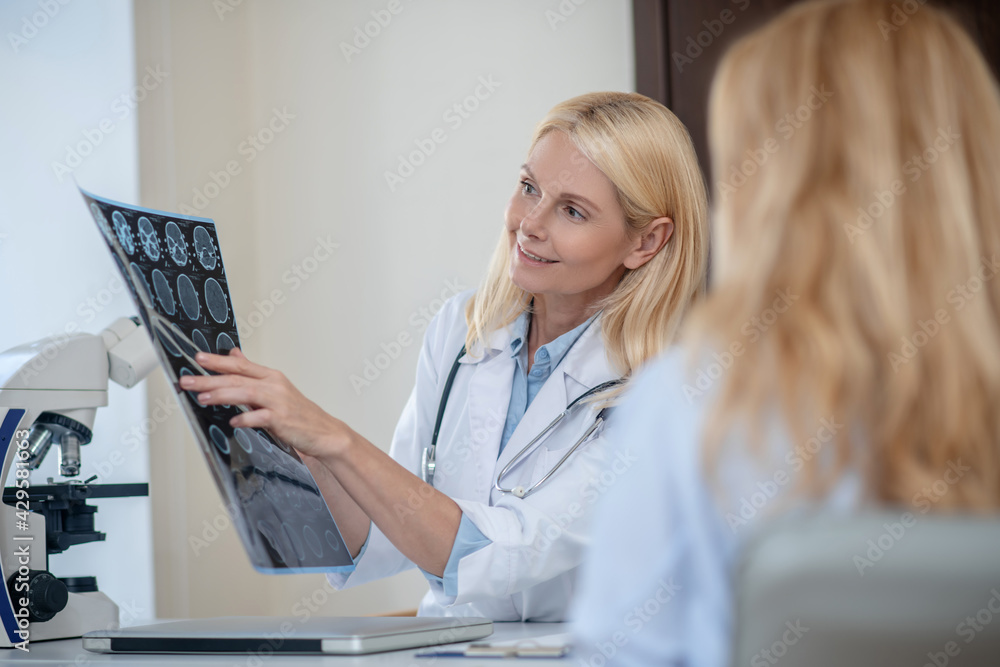 Doctor deciphering MRT scan showing it to patient Stock Photo | Adobe Stock