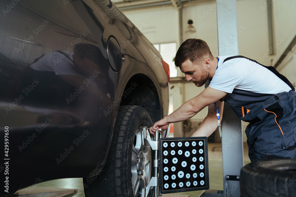 Car mechanic installing sensor adjustment and automobile wheel Stock ...