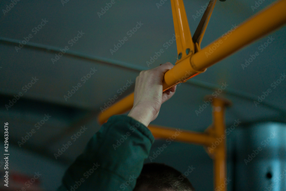 Foto de Man's holding onto a handle on a subway train. Passenger ...