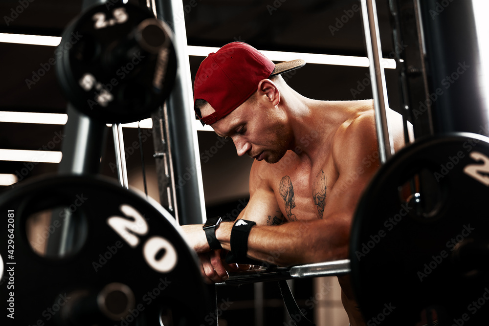 Closeup portrait of a muscular man workout with barbell at gym. Brutal ...