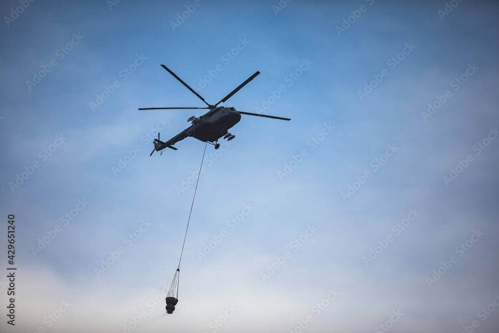 Fire fighting helicopter silhouette with bambi bucket for сarrying ...