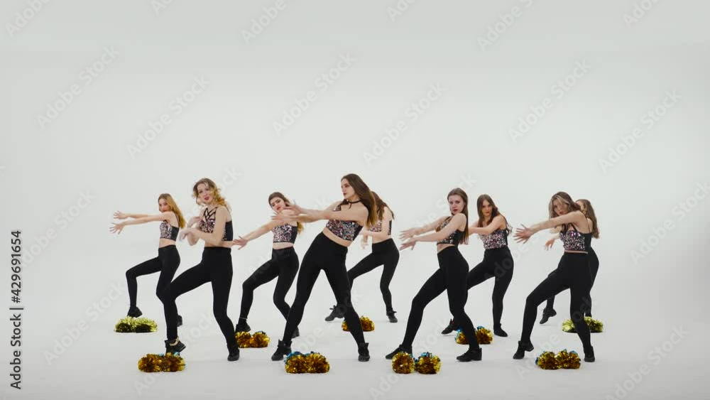 Group Of Athletic Cheerleaders In Silver Tops And Black Tight Leggings Are Dancing Cheering