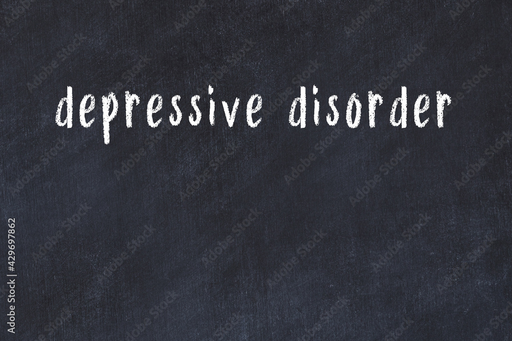 College chalk desk with the word depressive disorder written on in ...