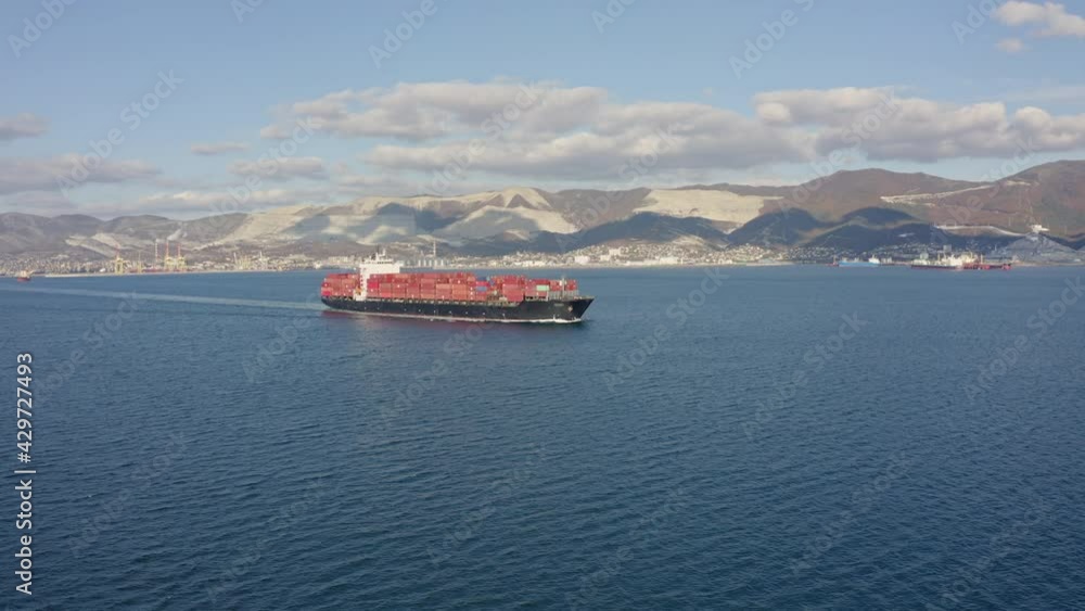 Video Stock Ultra large container ship sailing at sea, aerial side view ...