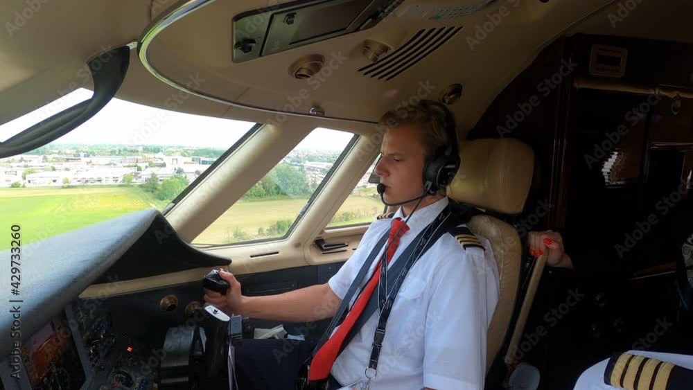 Male pilot, first officer in cockpit landing a jet airplane, hand ...