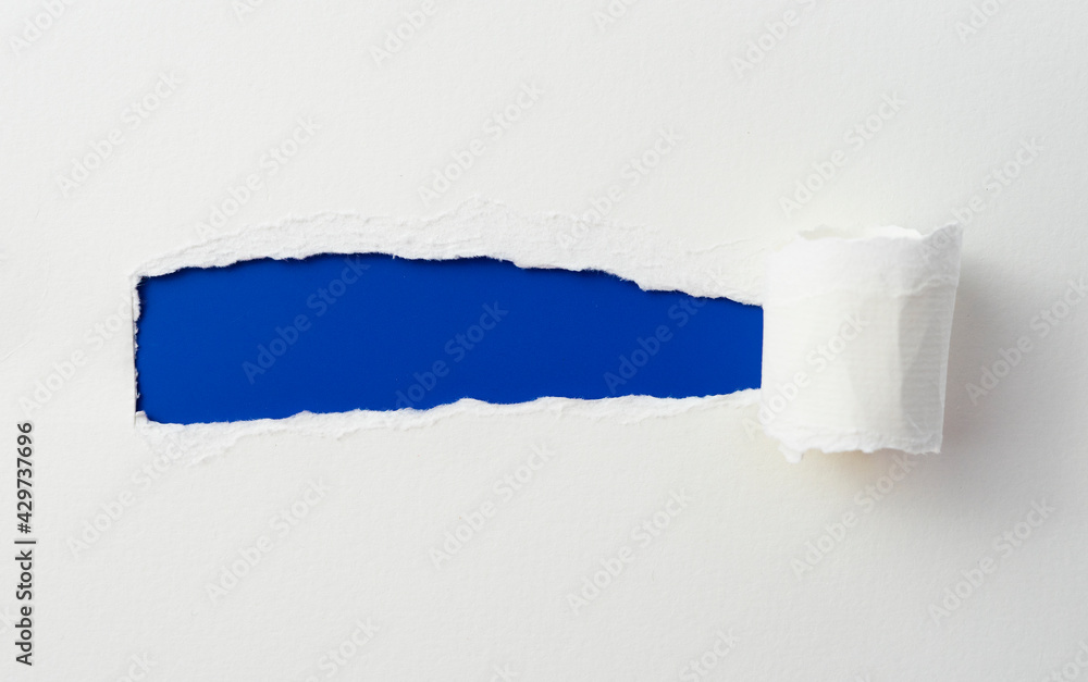 torn paper with the curled ripped sides. a long blue hole of torn on ...