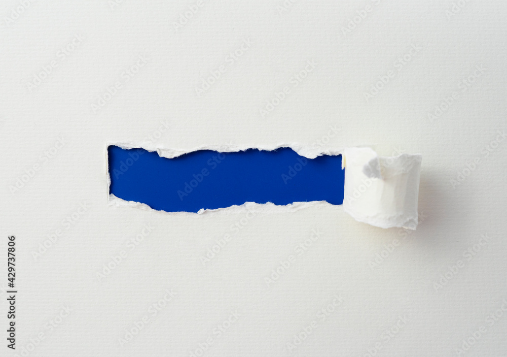 torn paper with the curled ripped sides. a long blue hole of torn on ...
