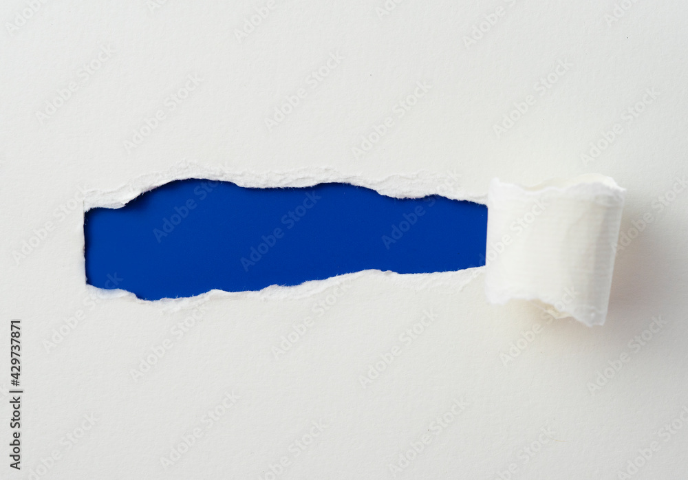 torn paper with the curled ripped sides. a long blue hole of torn on ...