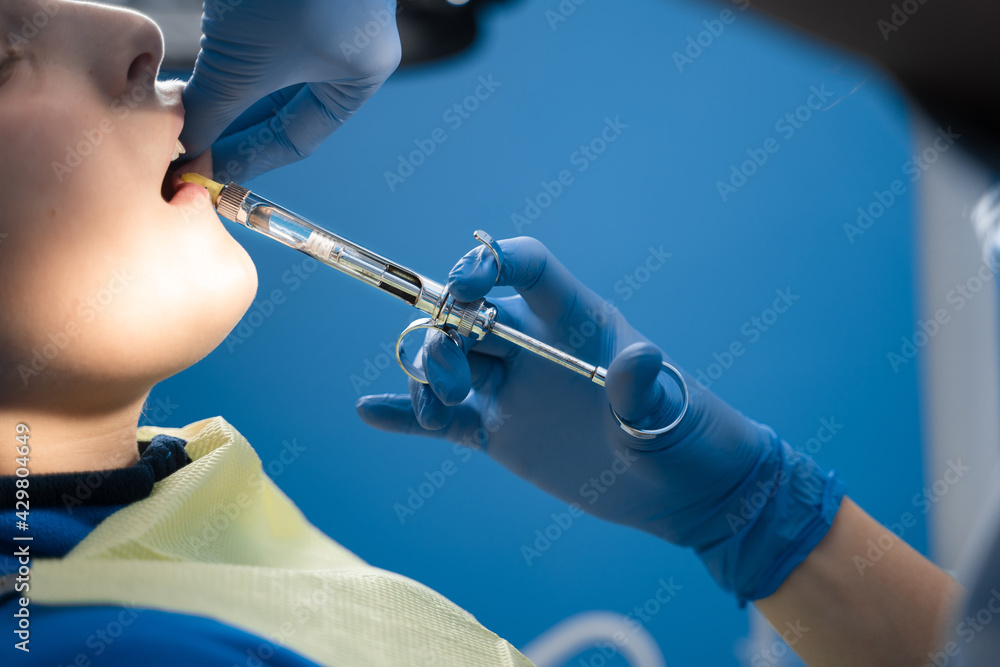 Dentist injects anesthesia syringe of the diseased teeth for the ...