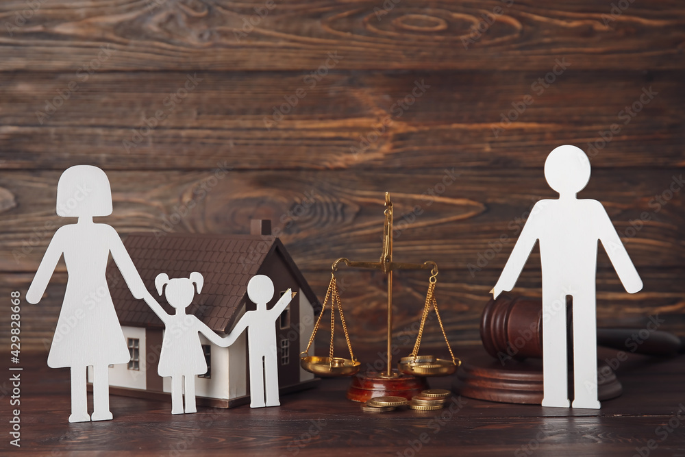 Figures of family with justice scales and house model on wooden ...