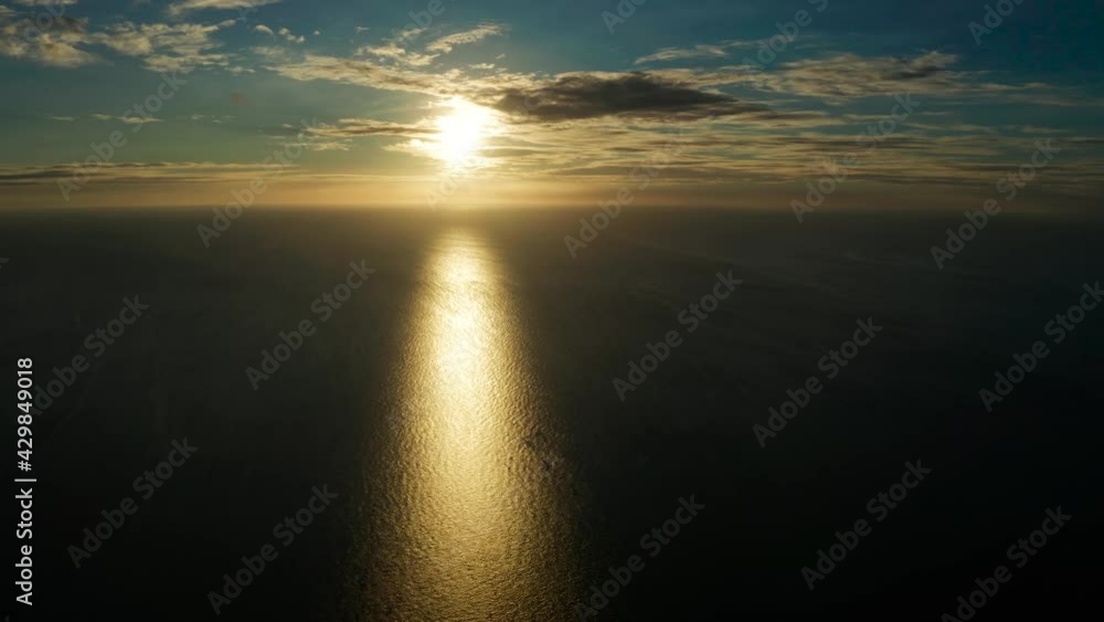Sunset above the sea surface with waves, aerial view. Reflected sun on ...