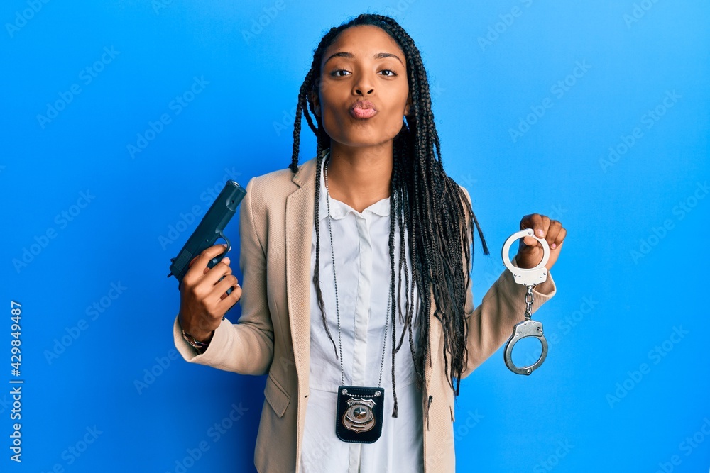 African American Police Woman Holding Gun And Handcuffs Looking At The