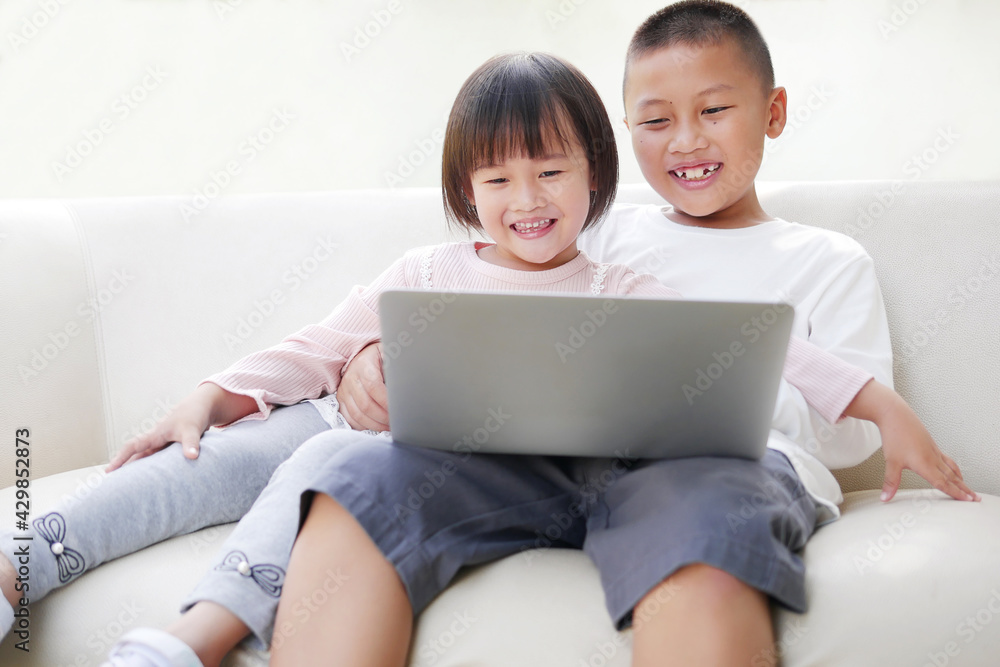 Happy Asian children brother and little sister smiling watching ...
