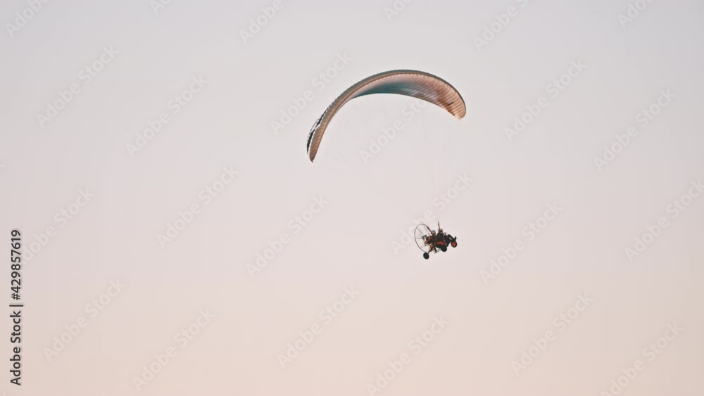 Zoom in footage of paramotor flying towards camera. Tandem motor ...