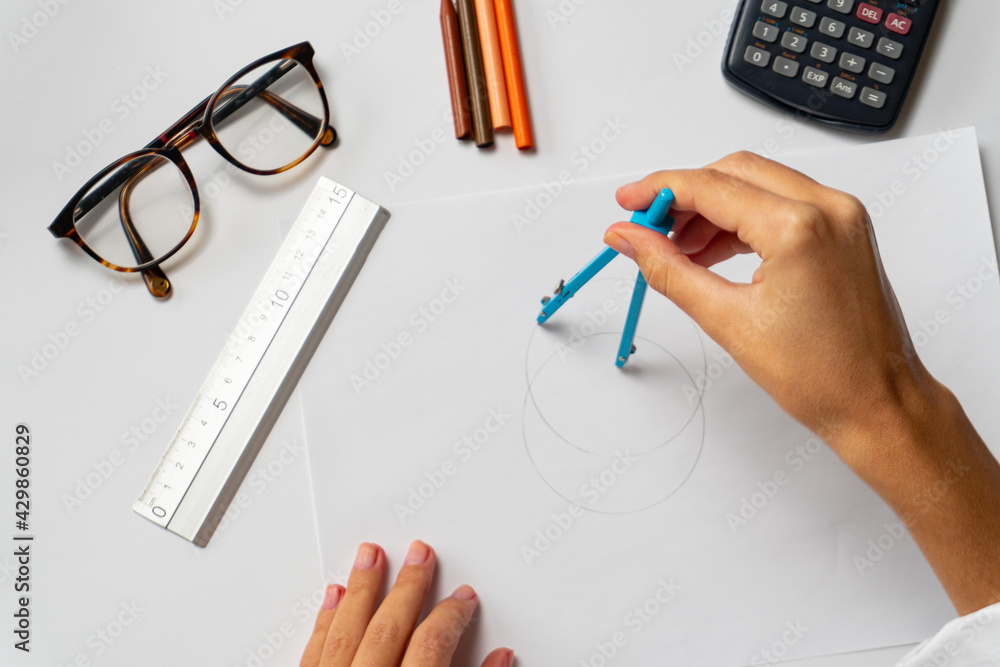 Drawing with a compass and a ruler on a blank sheet of paper. School ...