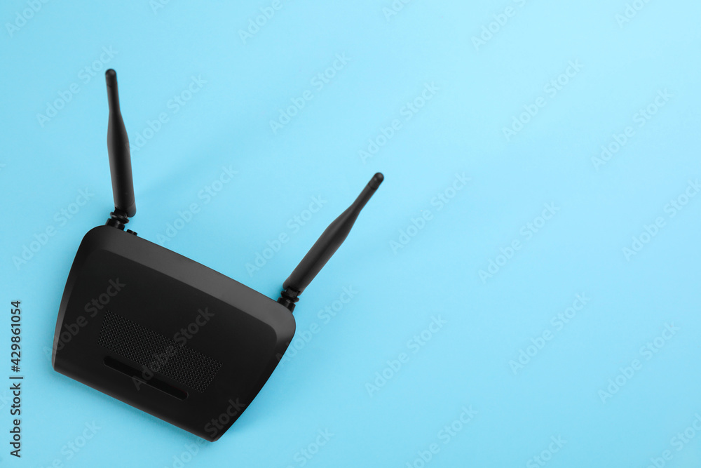 Modern Wi-Fi router on light blue background, top view. Space for text ...