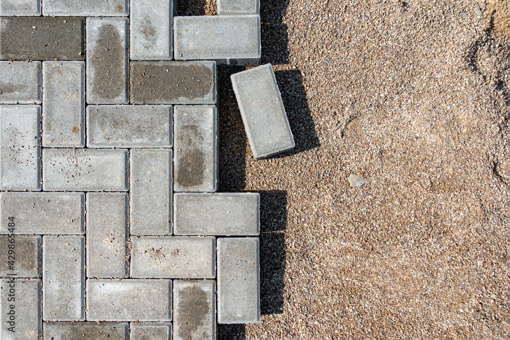 Laying gray concrete paving slabs in a house walkway. Process of ...