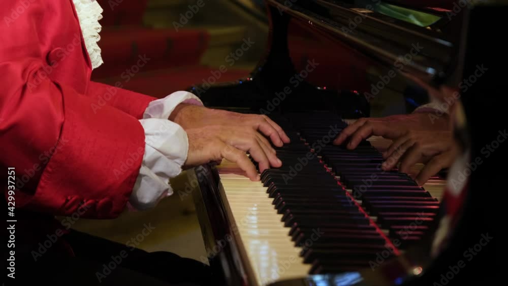 A man pianist, wearing clothes of the 18th century nobility, playing a ...