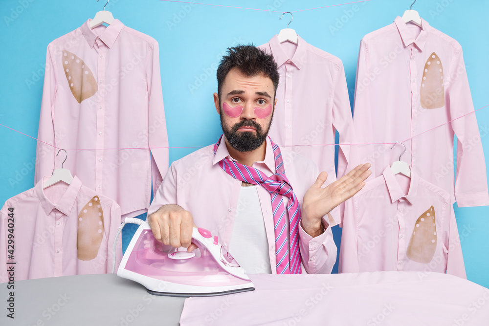 Hesitant bearded Caucasian man shrugs shoulders cannot decide what to ...