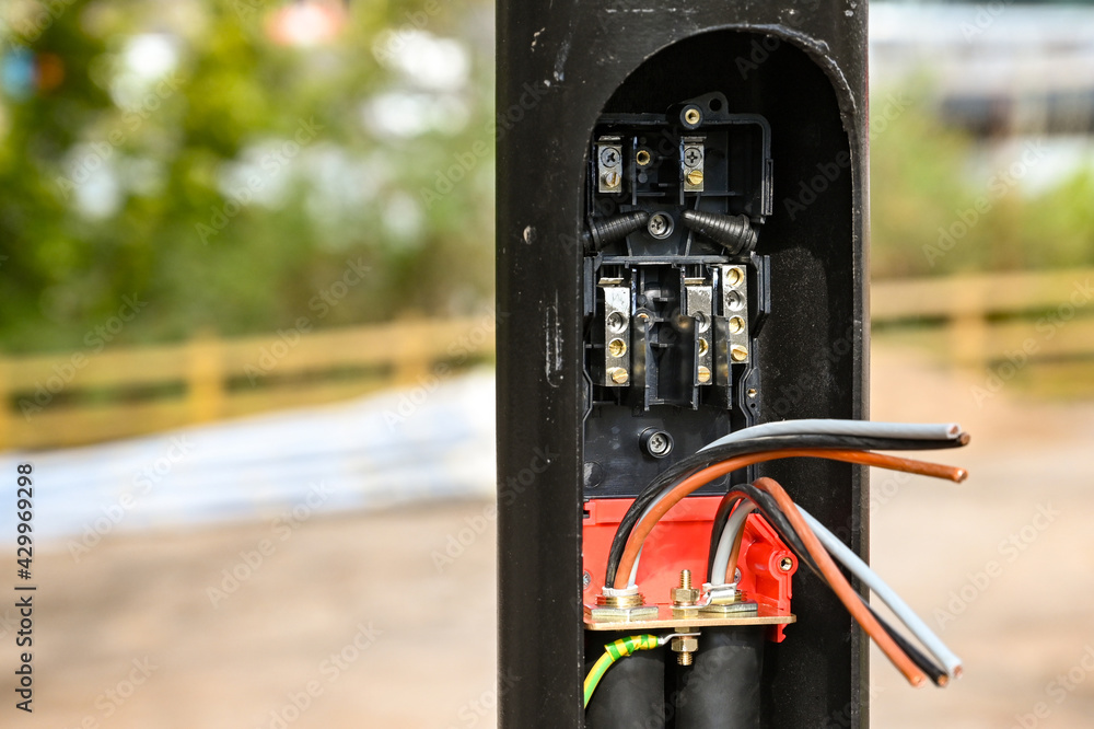 Base of a street light with cover open showing the installation of ...