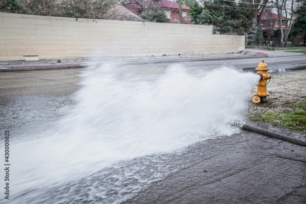 Yellow fire hydrant on corner of intersection gushing out water over ...
