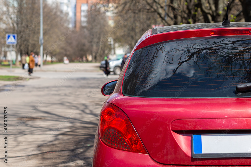 Back window of red car parked on the street in summer sunny day, rear ...