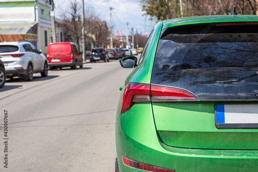 Back window of green car parked on the street in summer sunny day, rear ...