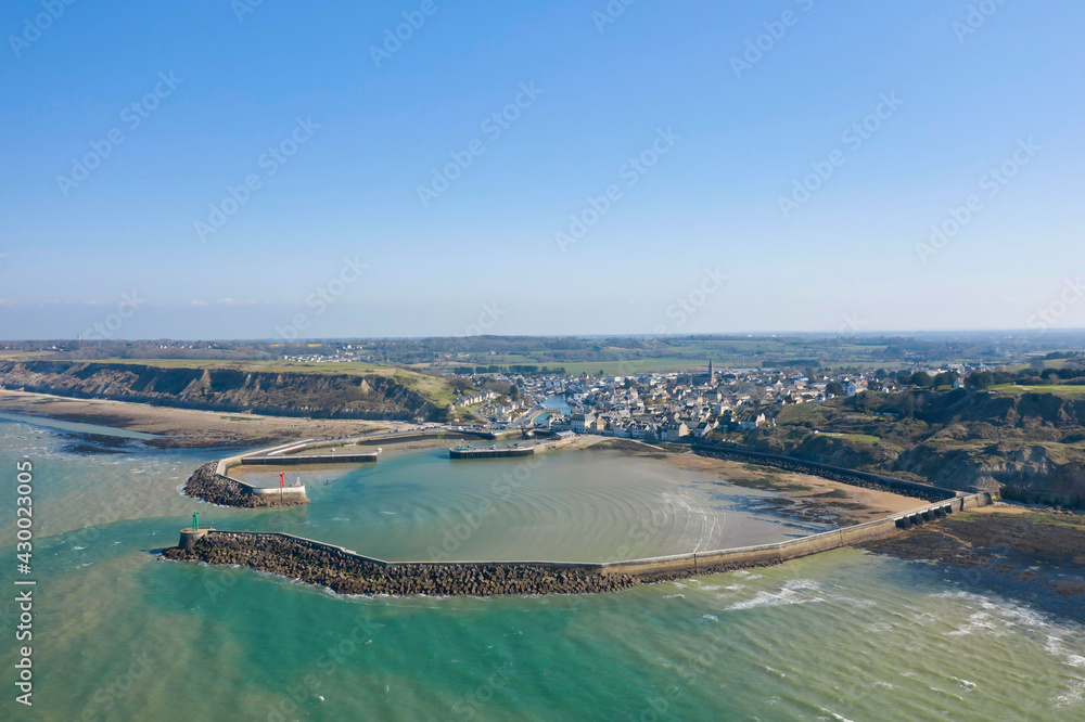 La plage, le port et la digue du port en Bessin en France, en Normandie, dans le Calvados, au ...
