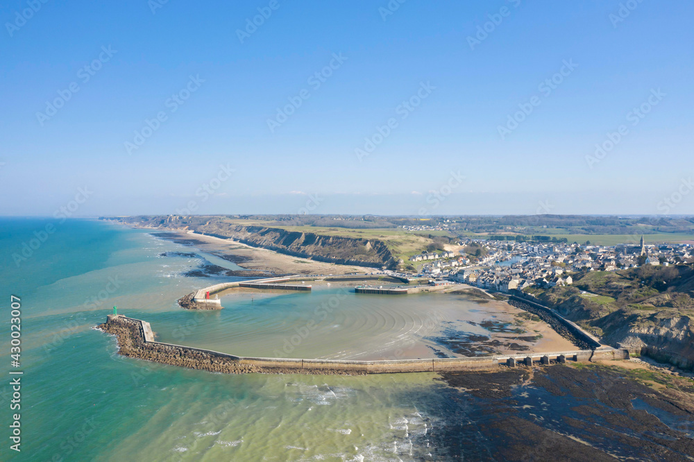 La plage, le port et la digue du port en Bessin en France, en Normandie ...