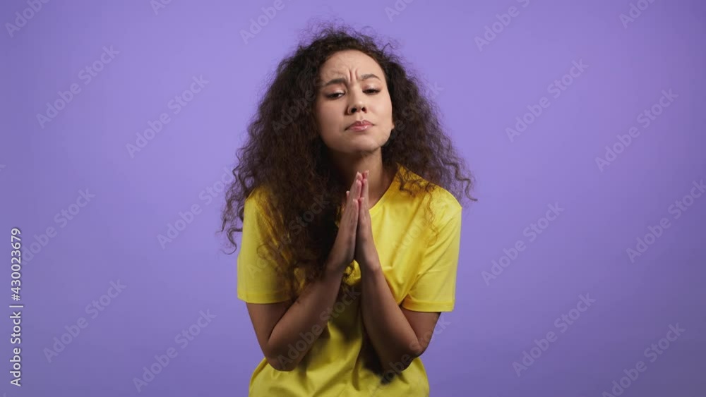 Vídeo do Stock: Pretty woman praying over violet background. Girl with ...