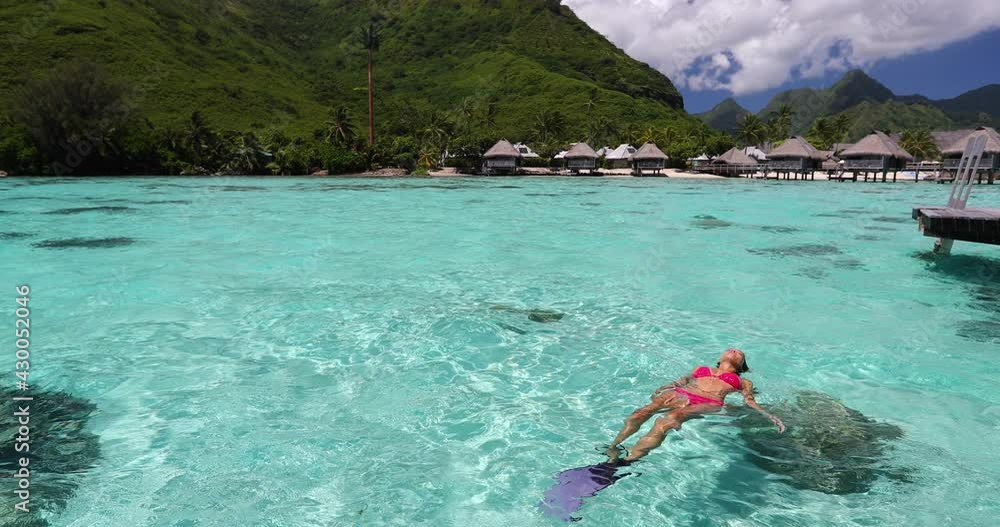 Luxury travel vacation tourist woman snorkeling in Tahiti ocean, Moorea island, French Polynesia ...