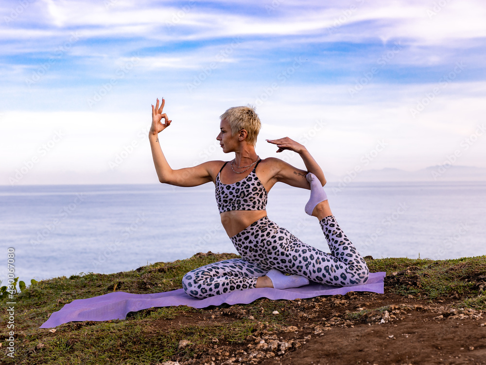 Foto de Sunrise yoga. Woman practicing Eka Pada Rajakapotasana, One ...