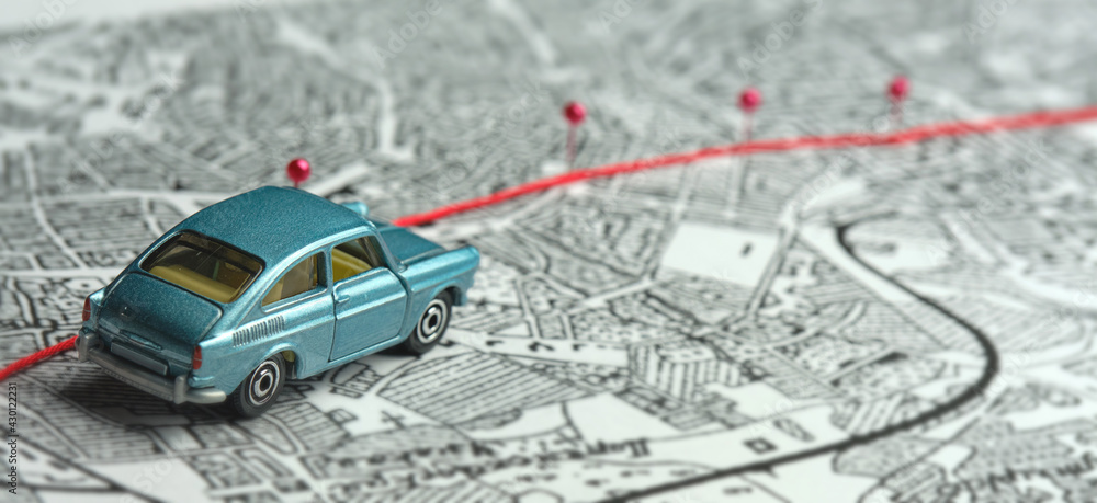 Concept. Following the route. A toy blue car drives across the map. The ...