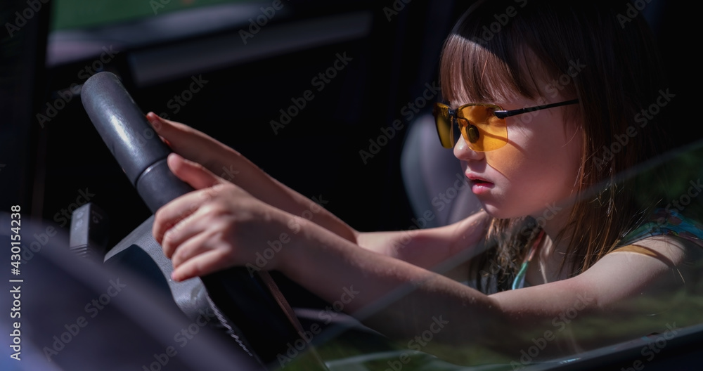 Dangers and risks of underage driving. Young beautiful child girl ...