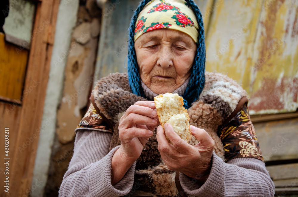 An elderly woman with a piece of bread. Old grandmother with a piece of ...