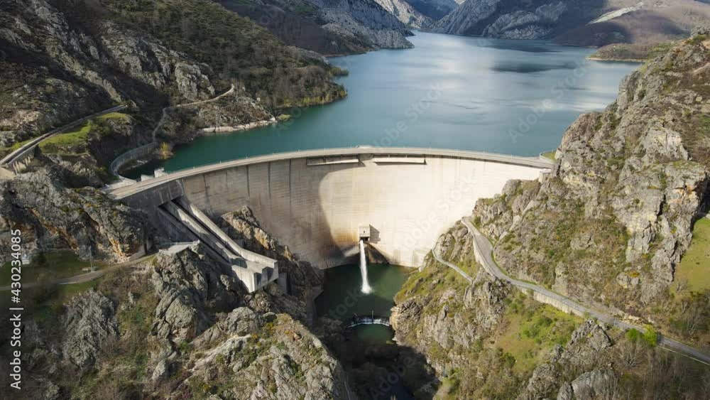Aerial drone footage. Water dam and reservoir lake, generating hydro electricity power renewable ...