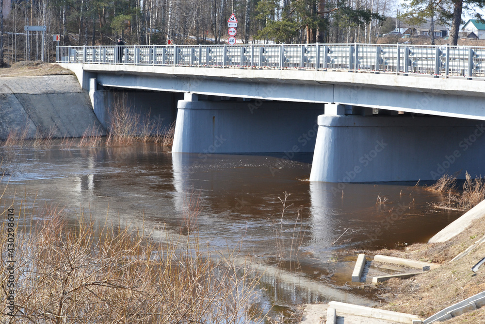 Side view of a road and pedestrian bridge on concrete supports with a ...