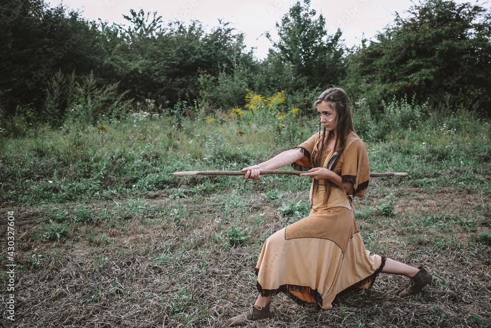 Apache tribe warrior striking with a spear, beautiful young girl in ...