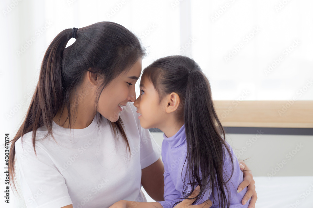 Young asian mother and daughter hug and touching nose on face with ...