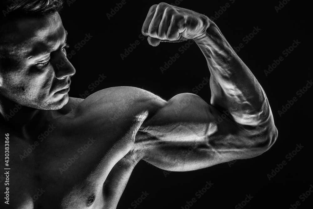 Strong Athletic Sexy Muscular Man on Black Background showing biceps ...