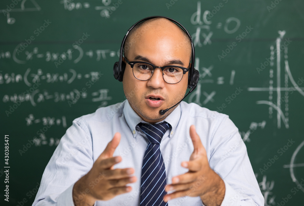Indian young teacher man looking at camera sitting teaching online ...