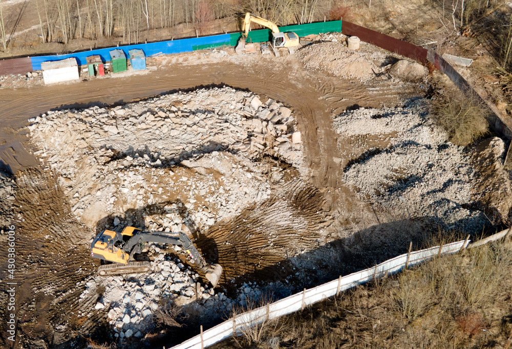 Recycling concrete and construction waste from demolition. Excavator at ...