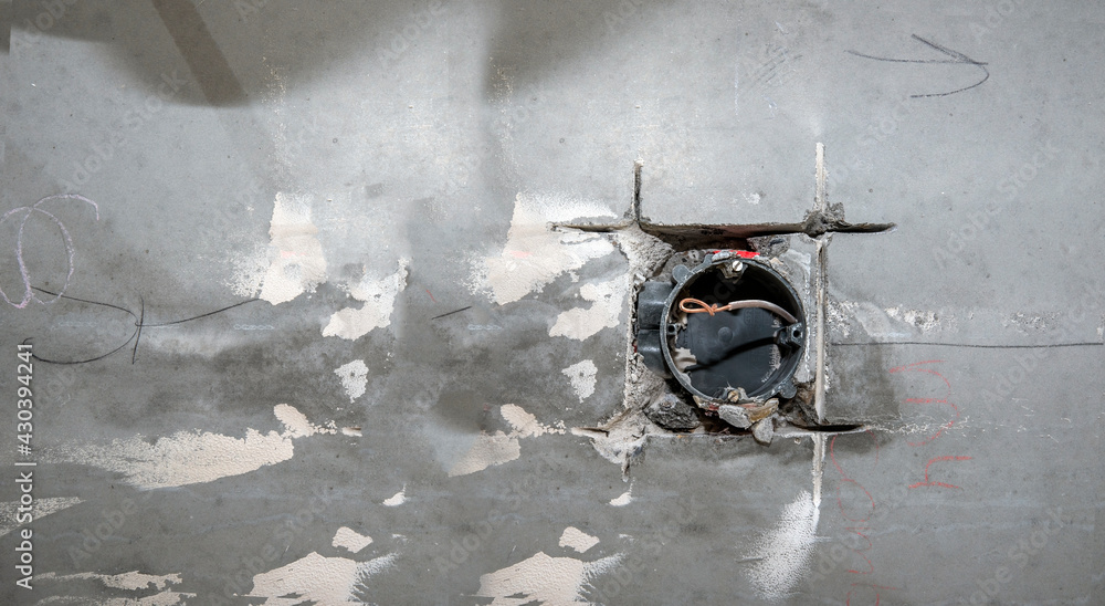Electrical wire and opened junction box on the concrete wall ...