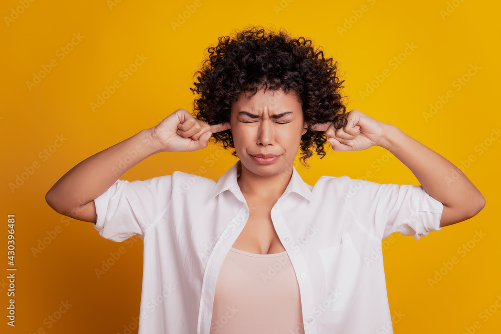 Beautiful irritated lady fingers cover ears avoid close eyes posing on ...