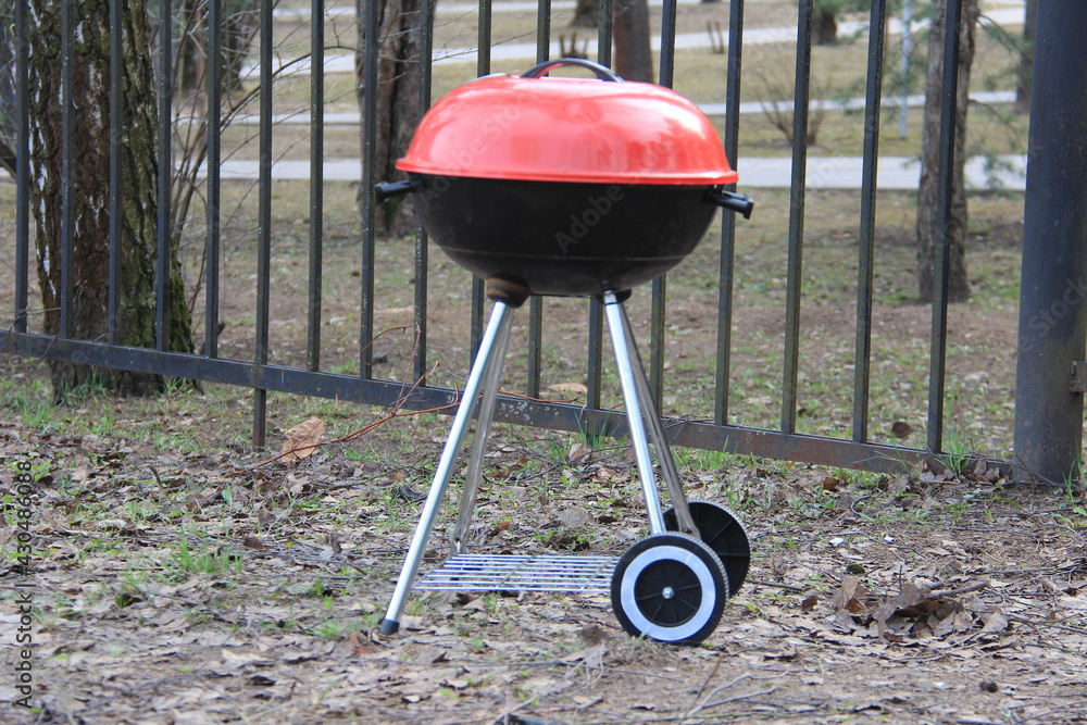 Small round charcoal grill ready for grilling at the summer picnic. B-B ...