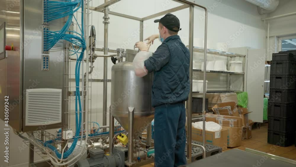 Vidéo Stock Dairy factory worker put jam inside steel tank and closing ...