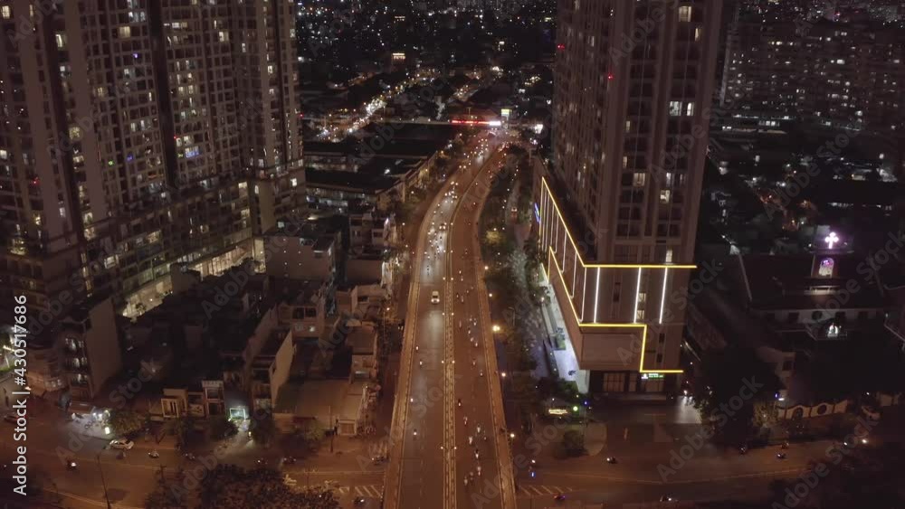 aerial view across busy traffic bridge at night following silver cars ...